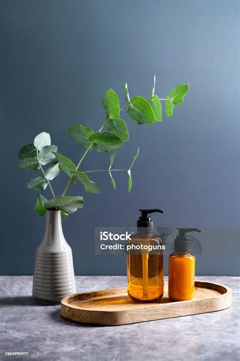 짙은 파란색 배경에 유칼립투스 식물이 있는 호박색 유리 디스펜서 병과 화병 천연 유기농 Spa 화장품 세트 샴푸와 샤워 젤용기