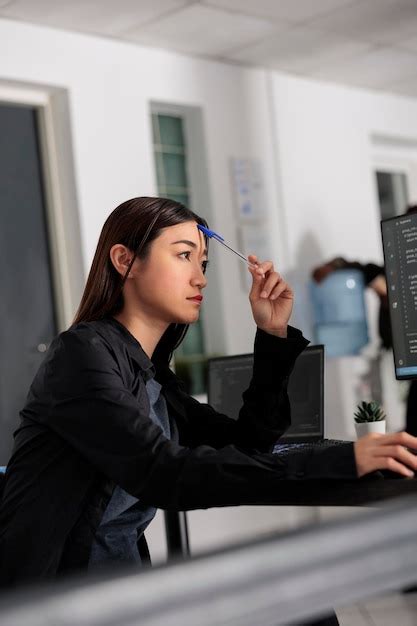 premium photo pensive asian web developer working on html code