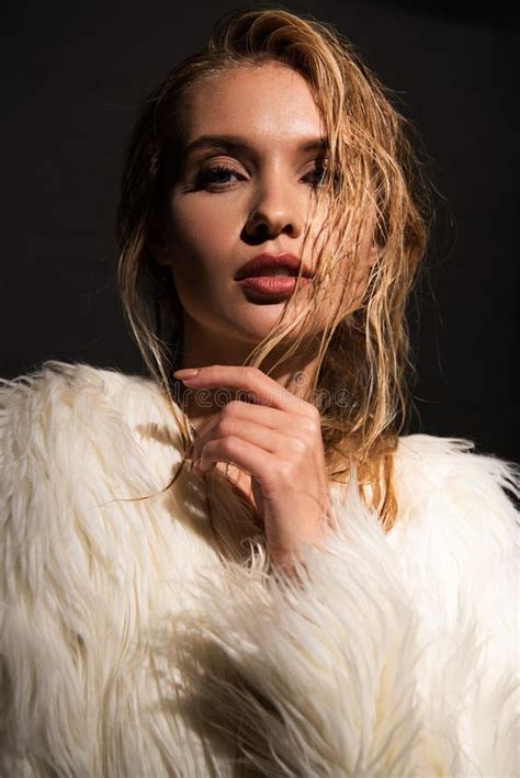 Young Woman With Wet Blonde Hair In White Faux Fur Coat Isolated On