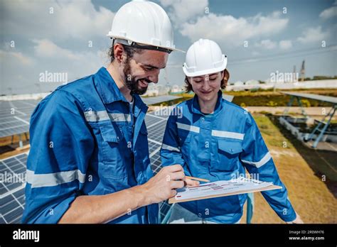 Solar Engineers Visually Examine Panel Arrays On Farm Sites Using Blueprints And Drawings To