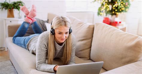 헤드폰과 노트북을 들고 크리스마스 때 집 소파에 누워 있는 젊은 여성 사진 Unsplash의 헤드폰 이미지