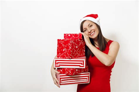 매력적인 미소와 아름 다운 백인 젊은 행복 한 여자 입고 빨간 드레스와 흰색 바탕에 선물 상자를 들고 크리스마스 모자 현재 격리와 산타 소녀입니다 새 해 휴일 2018 개념