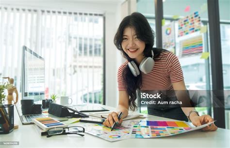 웃고 있는 여성 창조 디자이너는 현대 직장에 앉아 노트북 컴퓨터로 작업하고 있다 그래픽 디자이너에 대한 스톡 사진 및 기타