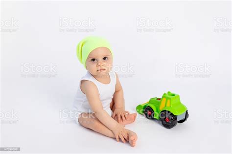 흰색 고립된 배경에 흰색 바디수트를 입은 귀여운 소년 타자기를 가지고 노는 아이들 아이들의 초기 발달 장난감 중 8개월 아기 텍스트를 위한 공간 남자 아기에 대한 스톡 사진