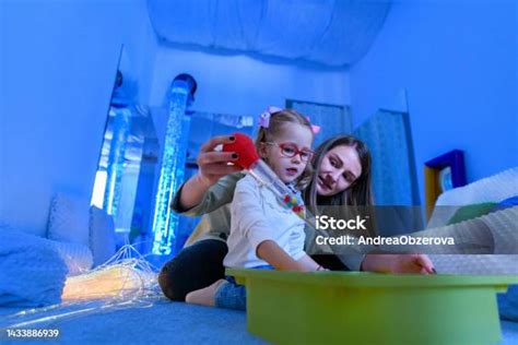 감각 자극 실에서 신체 장애가있는 어린이 Snoezelen 뇌성 마비와 함께 사는 어린이는 치료 세션 중에 치료사와 상호 작용합니다 교습에 대한 스톡 사진 및 기타 이미지