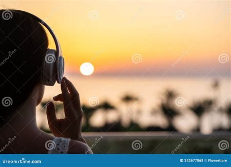 силуэт девушек слушающих музыку в наушниках стоящих на балконе и