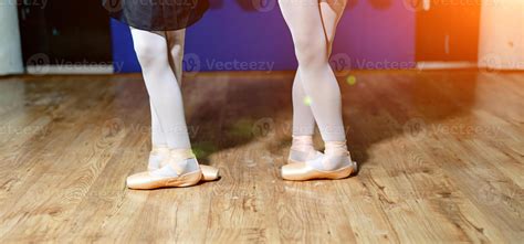 The Legs Of Two Young Ballerinas In White Tights And Pointes Performing