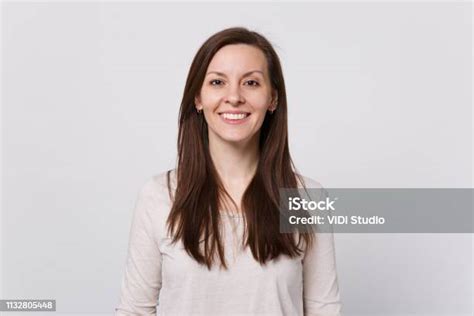 서 있는 밝은 옷에 매력적인 젊은 여자의 초상화와 스튜디오에서 흰색 벽 배경에 고립 된 카메라를 찾고 사람들은 진심으로 감정