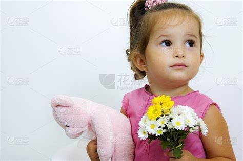 一个拿着花束和泰迪熊的小女孩