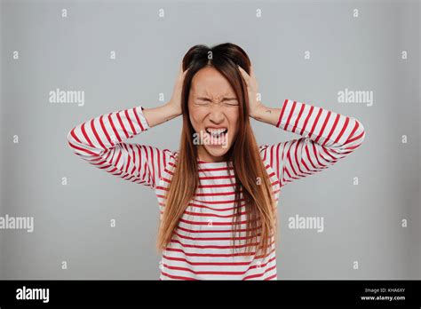Portrait Of A Crazy Asian Girl Standing With Hands In Her Hair And