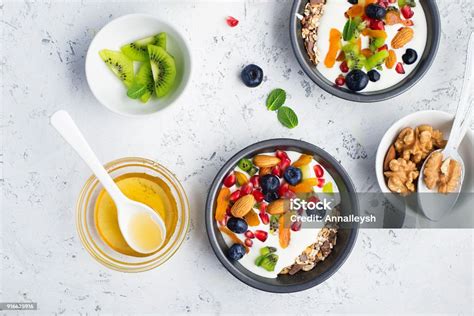 요구르트 우유 죽 그 라 놀라 아침 식사 다른 열매 견과류와 과일 키 위 석류 말린된 살구 블루베리 아몬드 꿀 Portionally 상위 뷰 음식 개념 0명에 대한 스톡