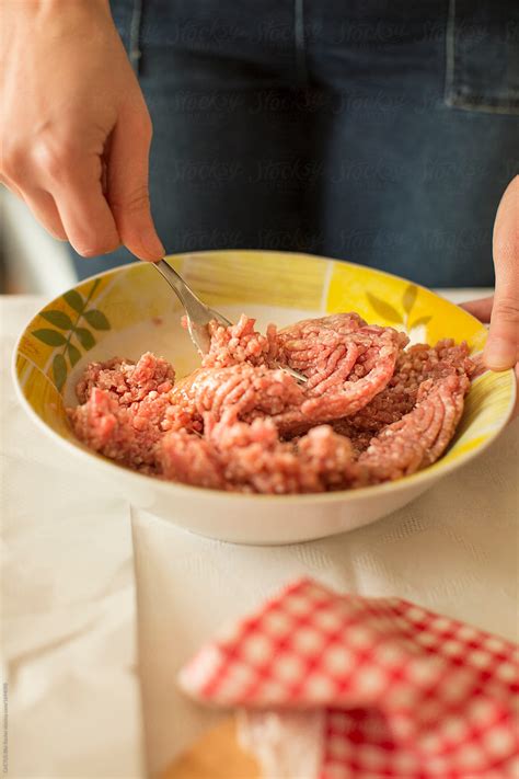 Woman Mixing Meat Rolled Roast With A Boiled Egg And Spinach Filling By Stocksy Contributor