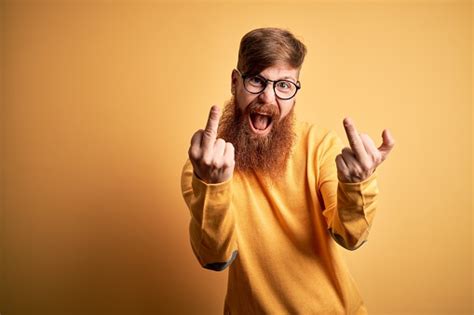 잘 생긴 아일랜드 빨강 머리 남자 수염 을 입고 안경을 통해 노란색 고립 된 배경 보여주는 중간 손가락 하 고 씨발 나쁜 표정 도발과 무례한 태도 비명 흥분 비명에 대한