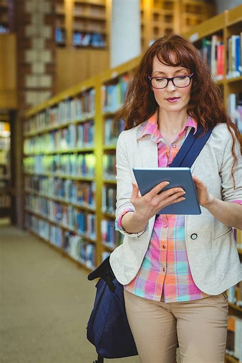 طالب ناضج في المكتبة باستخدام جهاز لوحي يلامس أدب الطلاب الناضجين صورة