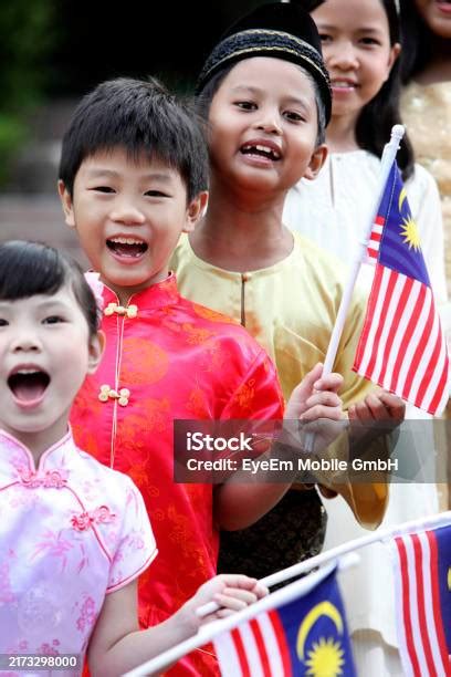 Potret Teman Lucu Berpakaian Adat Memegang Bendera Malaysia Foto Stok Unduh Gambar Sekarang