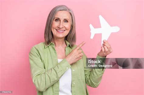 만족 사랑스러운 은퇴 한 아가씨의 사진 녹색 유행 옷을 입고 비행기 추천 분홍색 배경에 고립 된 티켓 구매 가리키기에 대한 스톡 사진 및 기타 이미지 Istock