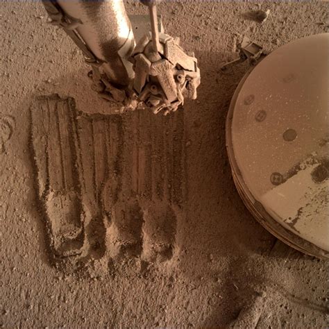 Insight Uses Its Robotic Arms To Scratch Away Some Of The Regolith