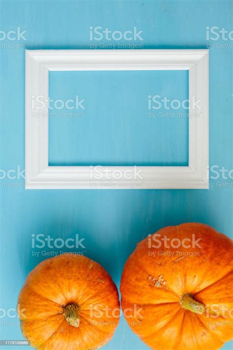 파란색 나무 배경 추수 감사절과 할로윈 개념에 사진 흰색 프레임 오렌지 호박 위에서 볼 수 있습니다 맨 위 보기 텍스트 및 디자인을 위한 공간을 복사합니다 스마트폰용 수직