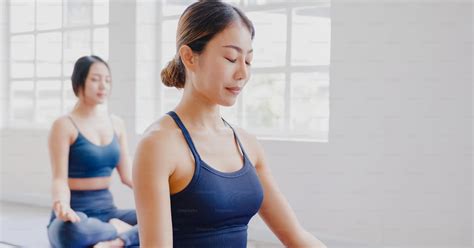 젊은 아시아 스포티 한 매력적인 사람들은 강사와 함께 요가 수업을 연습합니다 피트니스 스튜디오에서 건강한 라이프 스타일을 운동 하는 아시아 여성 그룹 스포츠 활동 체조