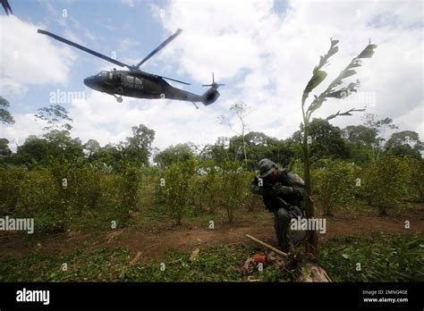A Counter Narcotics Police Officer Takes Cover As A Helicopter Lands On
