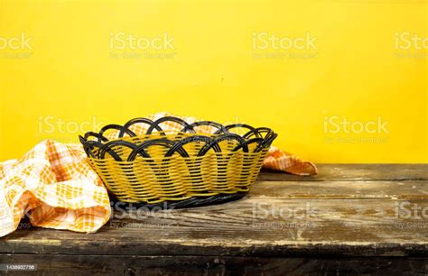 노란색 배경 위에 소박한 테이블에 식탁보가있는 빈 고리 버들 바구니 디자인 및 제품 디스플레이를위한 주방 모형 0명에 대한 스톡