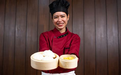 초상화 빨간 유니폼 모자를 쓰고 행복하게 웃고 광고를위한 음식 바구니를 제시하는 아름다운 전통 전문 중국 요리사 중 한 명 레스토랑 음식 호텔 컨셉 고급 요리에 대한 스톡