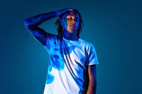 네온 불빛의 파란색 배경에 서 있는 몸에 빛을 반사하는 공포를 가진 아프리카 청년의 창의적인 초상화 18 19세에 대한 스톡 사진 및 기타 이미지 Istock