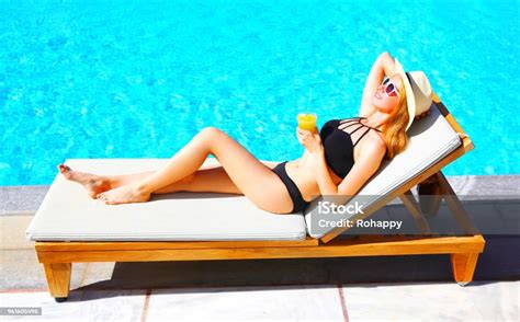 여름 휴가주스 Deckchair 푸른 물 수영장 배경에 컵에서 휴식 하는 행복 한 젊은 여자 갑판 의자에 대한 스톡 사진 및 기타 이미지 Istock