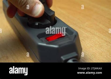 Insert Plug Into Extension Cord Socket By Pressing Red Push Button Switch With Your Finger