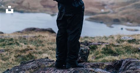 검은 재킷과 갈색 니트 모자를 쓴 남자가 낮 동안 갈색 바위 위에 서 있다 사진 Unsplash의 무료 사진 이미지