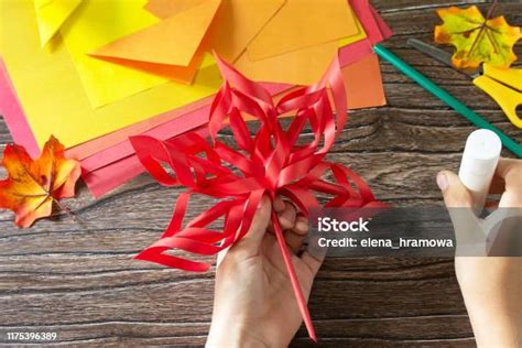 아이는 종이 잎을 수집합니다 나무 배경에 가을에 색종이 잎 어린이를위한 종이공예품 어린이 예술 프로젝트 텍스트에 사용할 수 있는 여유 공간입니다 10월에 대한 스톡 사진 및