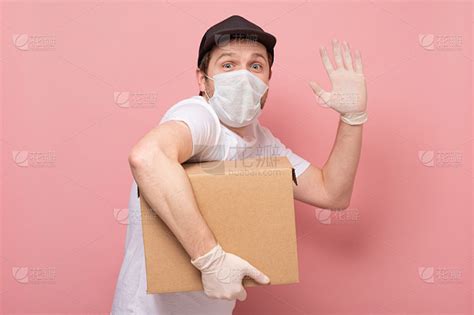 送货员拿着装着医用橡胶手套和口罩的纸箱
