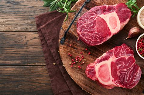 오소 부코 생 스테이크 고기 바베큐 고기 원시 신선한 크로스 컷 송아지 정강이와 조미료 후추 로즈마리 백리향 및 오래된 나무