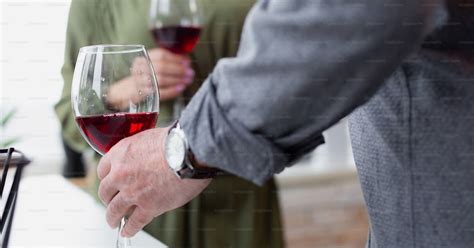 레드 와인 한 잔 손목에 시계를 차고 테이블 위에 서 있는 레드 와인 한 잔을 들고 있는 남성 손의 클로즈업 샷 사진 Unsplash의 조화 이미지