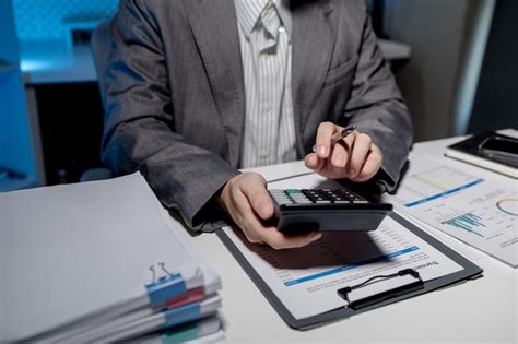 Premium Photo An Employee Is Seriously Calculating Numbers In An Important Document A