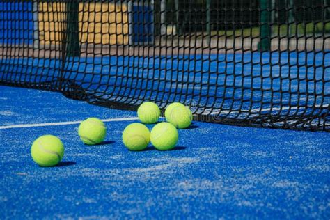 Padel Balls Next To The Net On A Blue Court An Eye Level View Stock