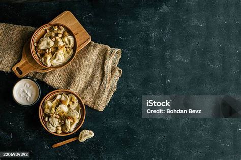 어둡고 소박한 배경에 사워 크림을 곁들인 삼베에 도자기 그릇에 고기와 양파를 곁들인 전통적인 만두의 평면도 오른쪽의 복사 공간 0명에 대한 스톡 사진 및 기타 이미지