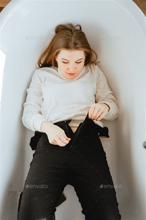 Girl Lying In The Bath Takes Off Her Pants Stock Photo By Senencov