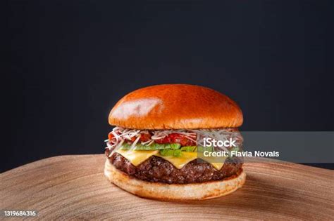 토마토 소스를 곁들인 맛있는 쇠고기 버거 파마산 치즈 양상추를 어두운 배경의 나무 테이블에 얹습니다 복사 공간 특별한 식품 및 음료에 대한 스톡 사진 및 기타 이미지