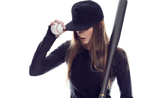 순수한 흰색 배경에 모자를 가진 스포츠 복장에서 공과 박쥐로 포즈를 취하는 Winsome Sportive 백인 여성 야구 선수 운동 선수 야구 방망이에 대한 스톡 사진 및