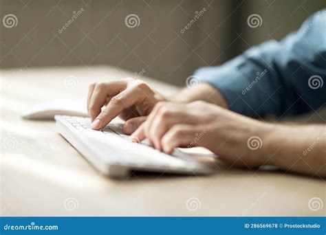 Unrecognizable Man Typing On Computer Keyboard While Sitting At Desk