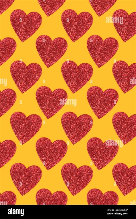 Repetitive Pattern Made Of Red Glittering Hearts Creative Layout On A Yellow Background Stock