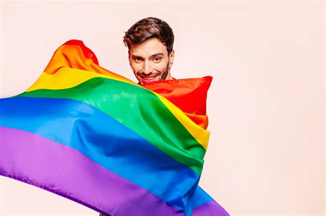 남자 와 A 게이 자부심 플래그 에 스튜디오 위에 베이지 색 배경 남자에 대한 스톡 사진 및 기타 이미지 남자 미소 20 24세 Istock