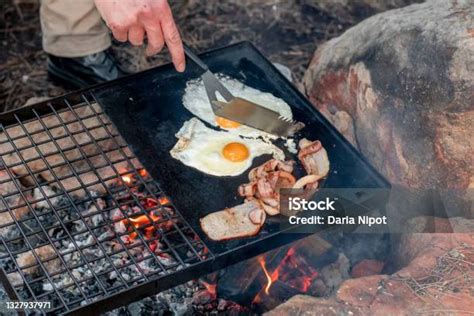 아침 캠프 요리 캠프 파이어 위에 주철 판에 바삭바삭한 베이컨과 달걀을 굽습니다 건강에 좋지 않은 음식에 대한 스톡 사진 및