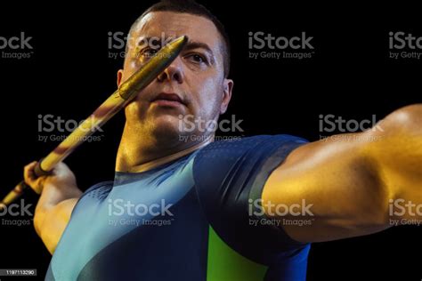 네온 빛에 검은 스튜디오 배경에 고립 된 창을 던지는 에서 연습 하는 남성 선수 Championship에 대한 스톡 사진 및
