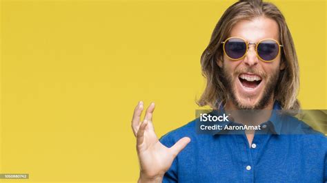 미친 미친 비명 제기 및 닫힌 눈 흥분 하는 무기와 성공을 위한 축 하 하는 고립 된 배경 위에 선글라스를 입고 긴 머리를 가진