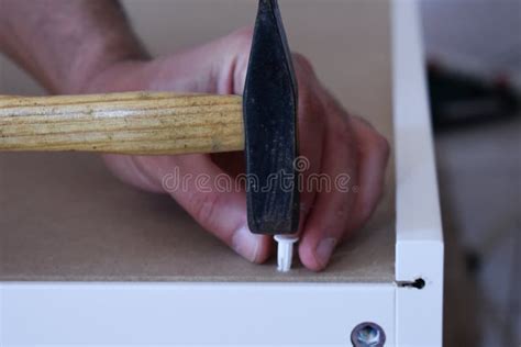 Man Assembling Furniture At Home Male Hands Using A Hammer While Assembling A Wardrobe At Home