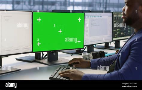 Engineer Using Green Screen Computer In Server Room Developing