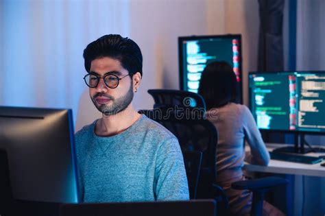 Asian Software Developers Working On Multiple Screens Displaying Code And Application Diagrams