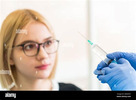 Fear Of Injections Frightened Girl Looks At Syringe Needle During